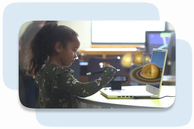 Elementary student in a classroom interacts with a 3D model of a planet ...